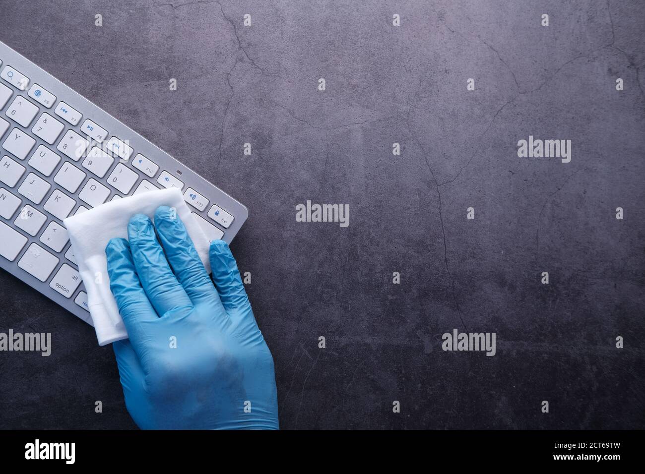 hand in blue rubber gloves and white tissue disinfecting keyboard Stock ...