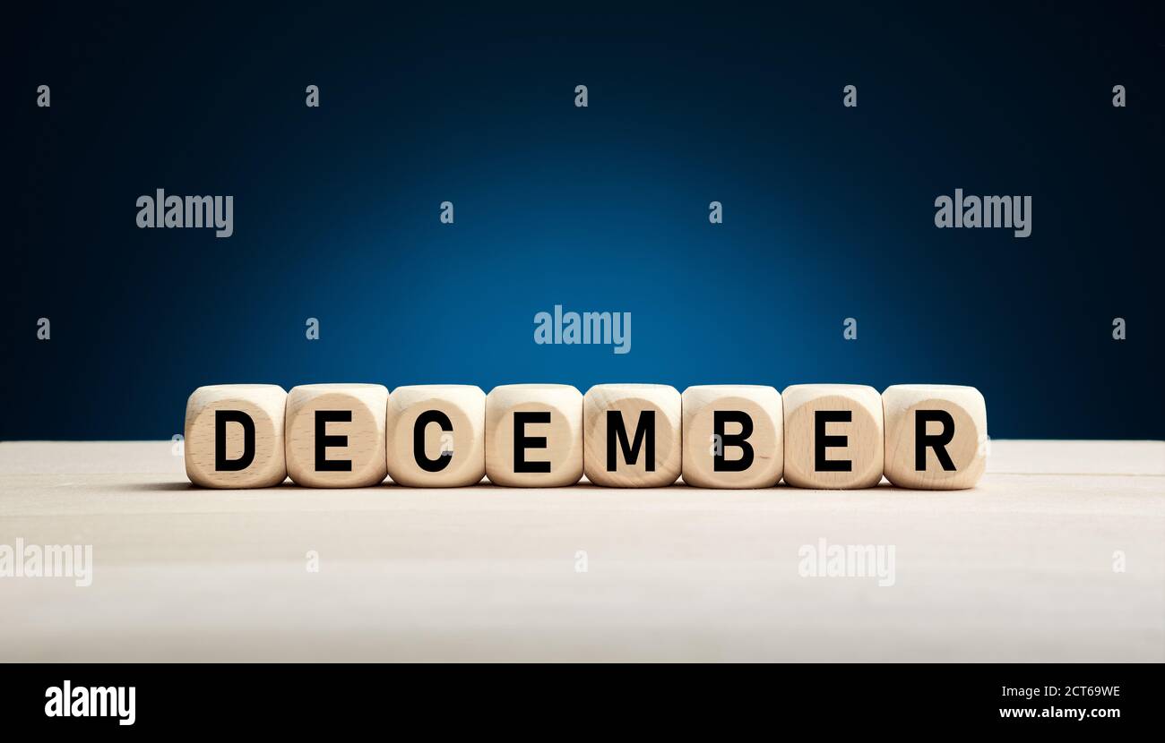 The month December written on wooden cubes with blue winter background ...