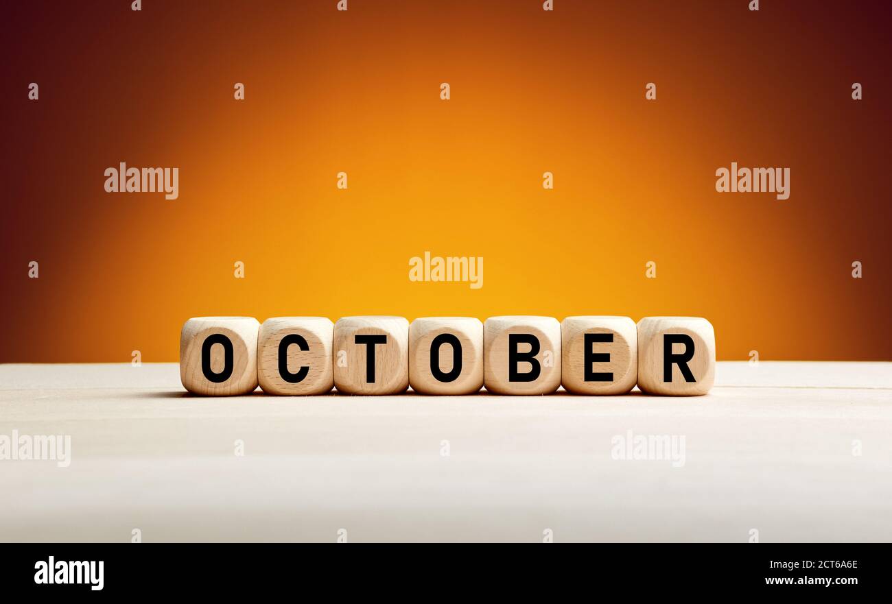 The month October written on wooden cubes with autumn background with ...
