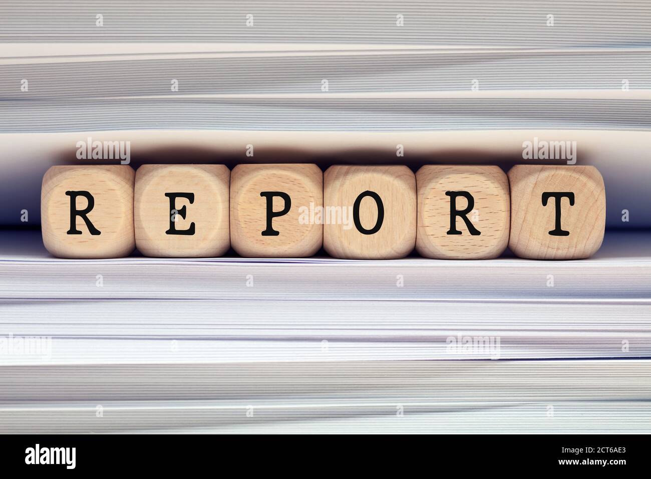 The word report on wooden blocks against paper files and folders ...