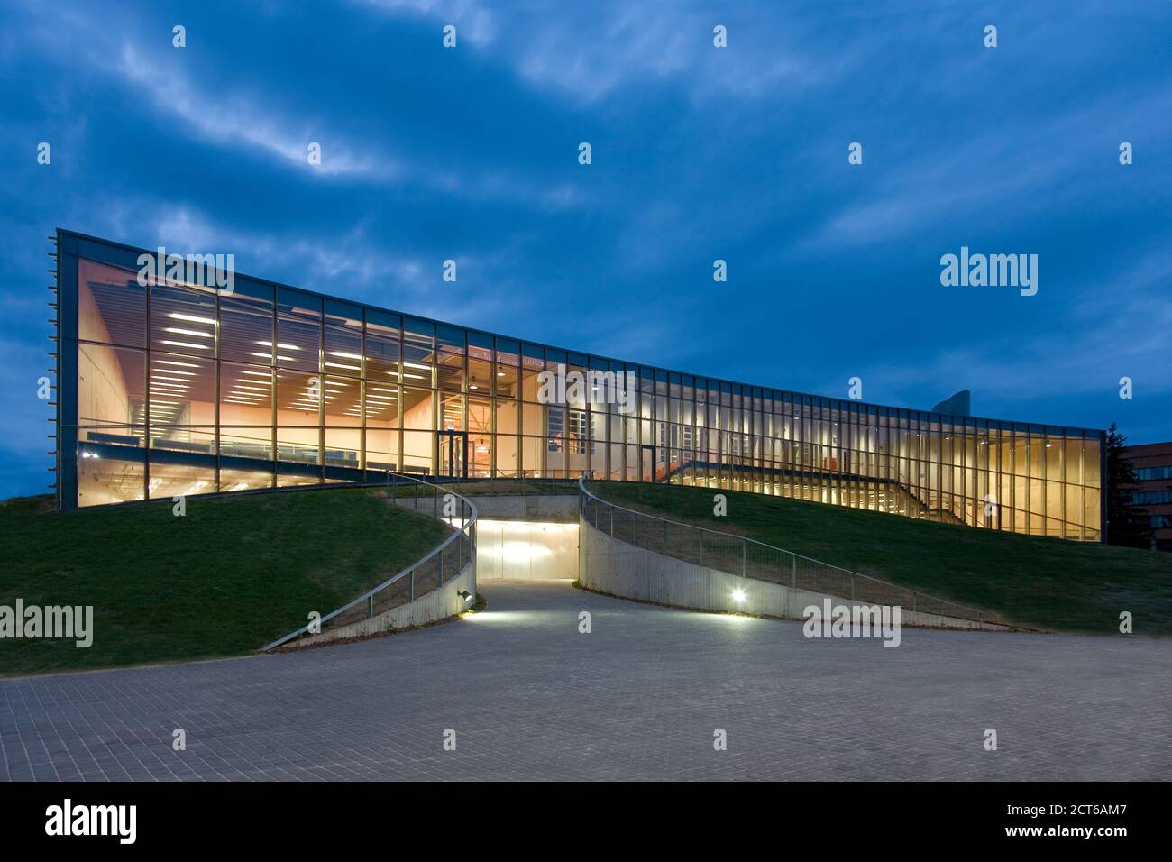 Modern university buildings, glass facade lit up at night, on a curved ...