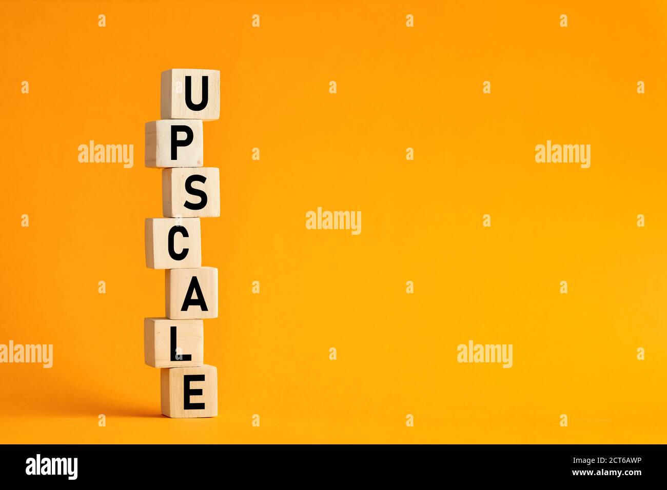 The word upscale on wooden cubes against yellow background. Upscale ...
