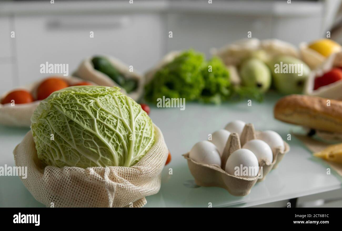 Vegetables, fruits, eggs in reusable eco cotton bags on table. Zero ...