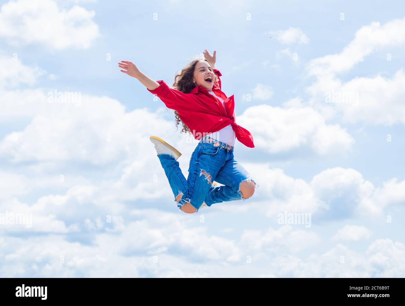 smiling child jumping so high. carefree and joyful. kid fashion style ...