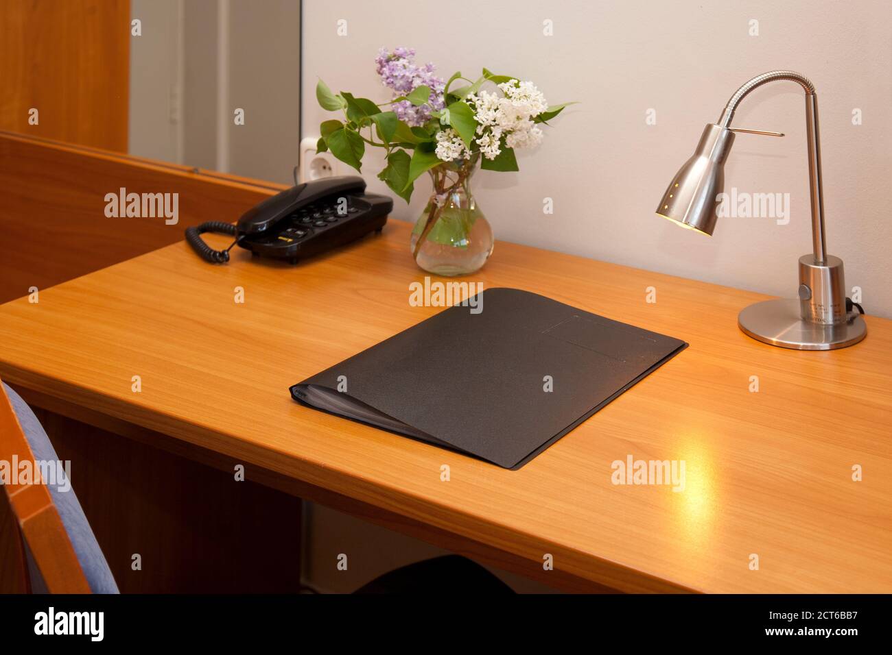 Hotel Room Desk with phone, pad and angled light Stock Photo - Alamy