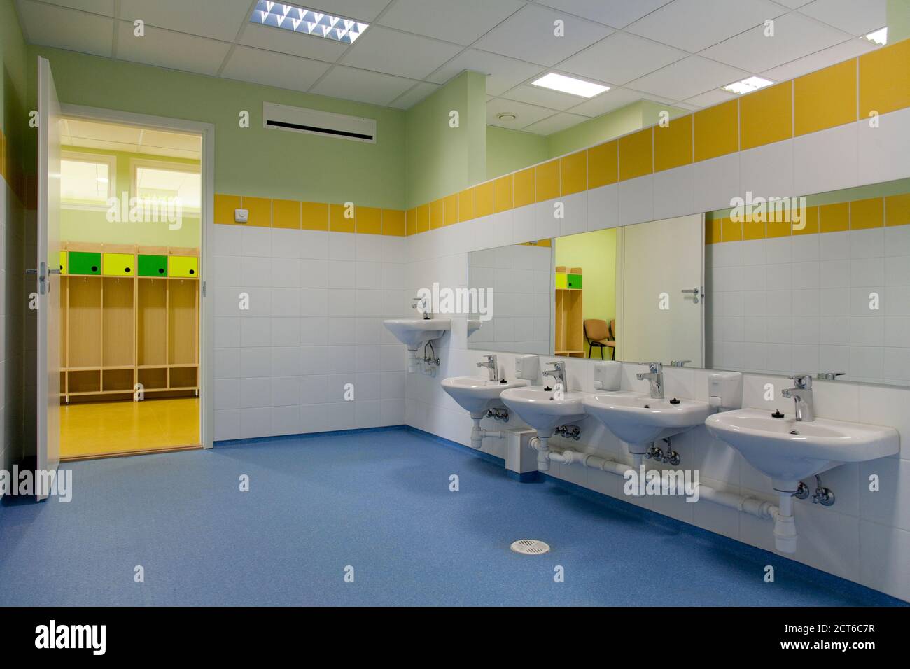 School Restroom, modern style with yellow paint and blue flooring Stock ...