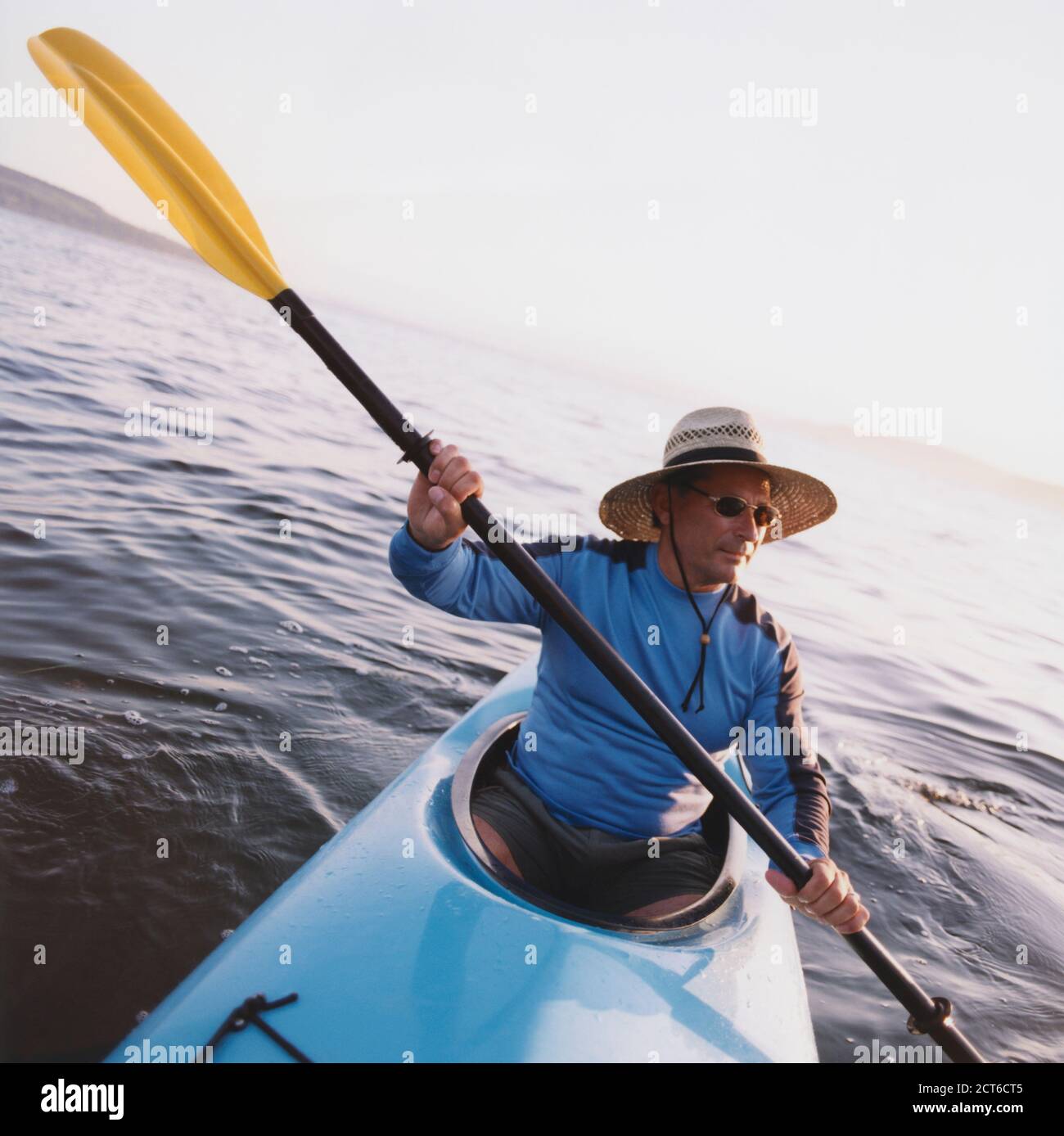 Man sea kayaking at dusk Stock Photo - Alamy