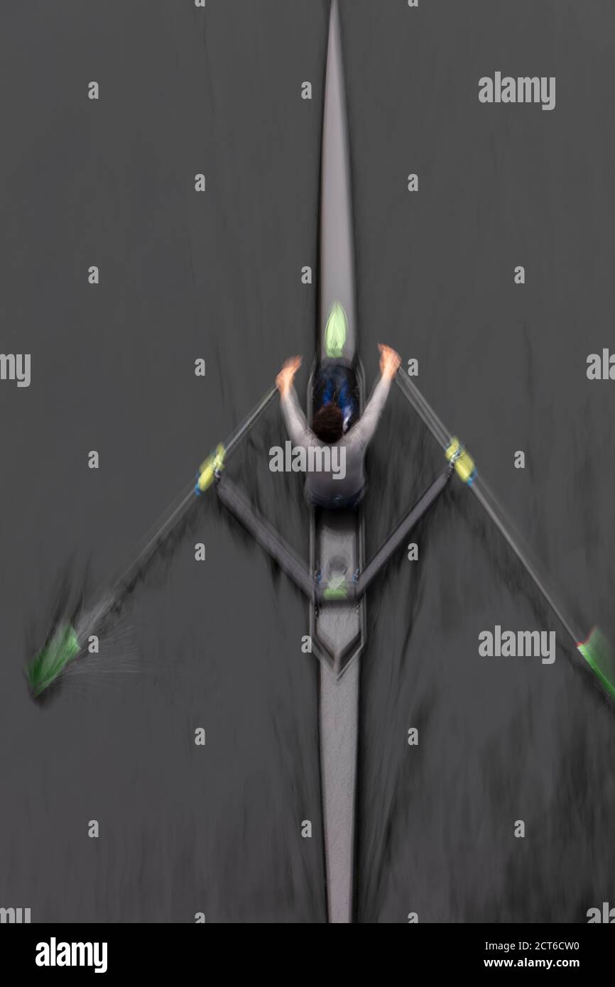 A single scull boat and rower on the water, view from above. Motion ...