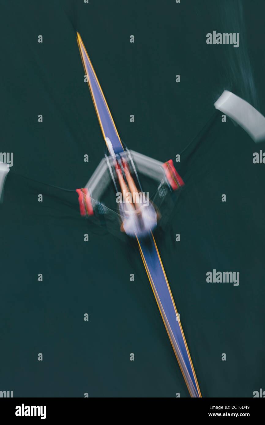 A single scull boat and rower on the water, view from above. Motion ...