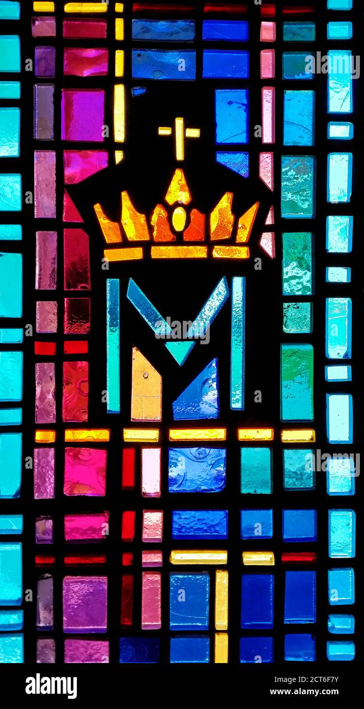 stained glass window; gold crown; cross; M; bright multicolor ...