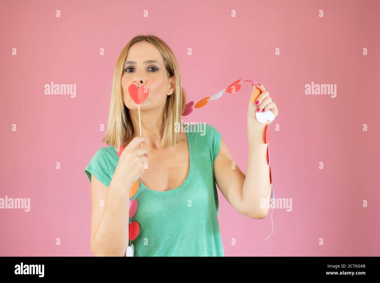 Studio portrait of a pretty blond woman wearing a ribbon of hearts ...