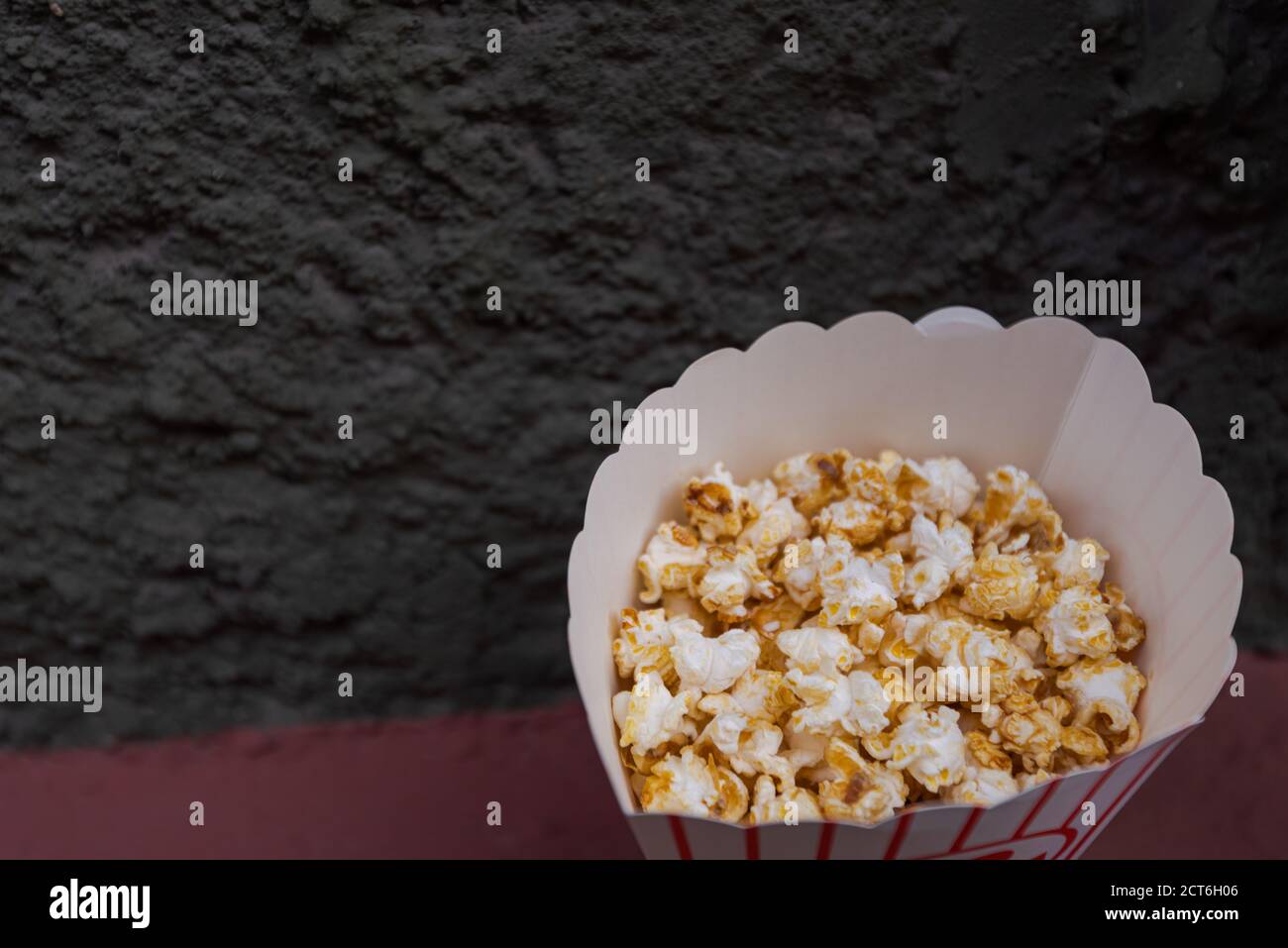 Bag with old popcorn standing near dark wall of building Stock Photo ...