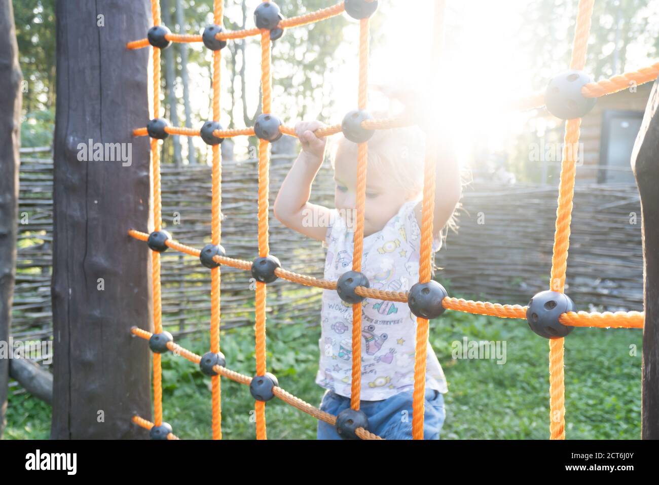 Cute caucasian child climbing net at playground Stock Photo - Alamy