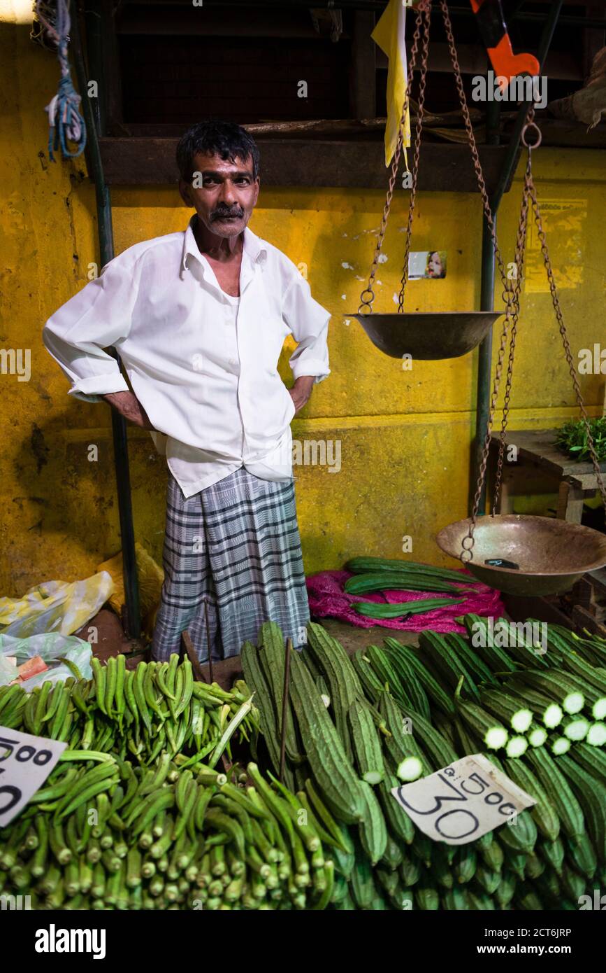 Portrait of a vegetable seller at his market stall in Kandy market ...