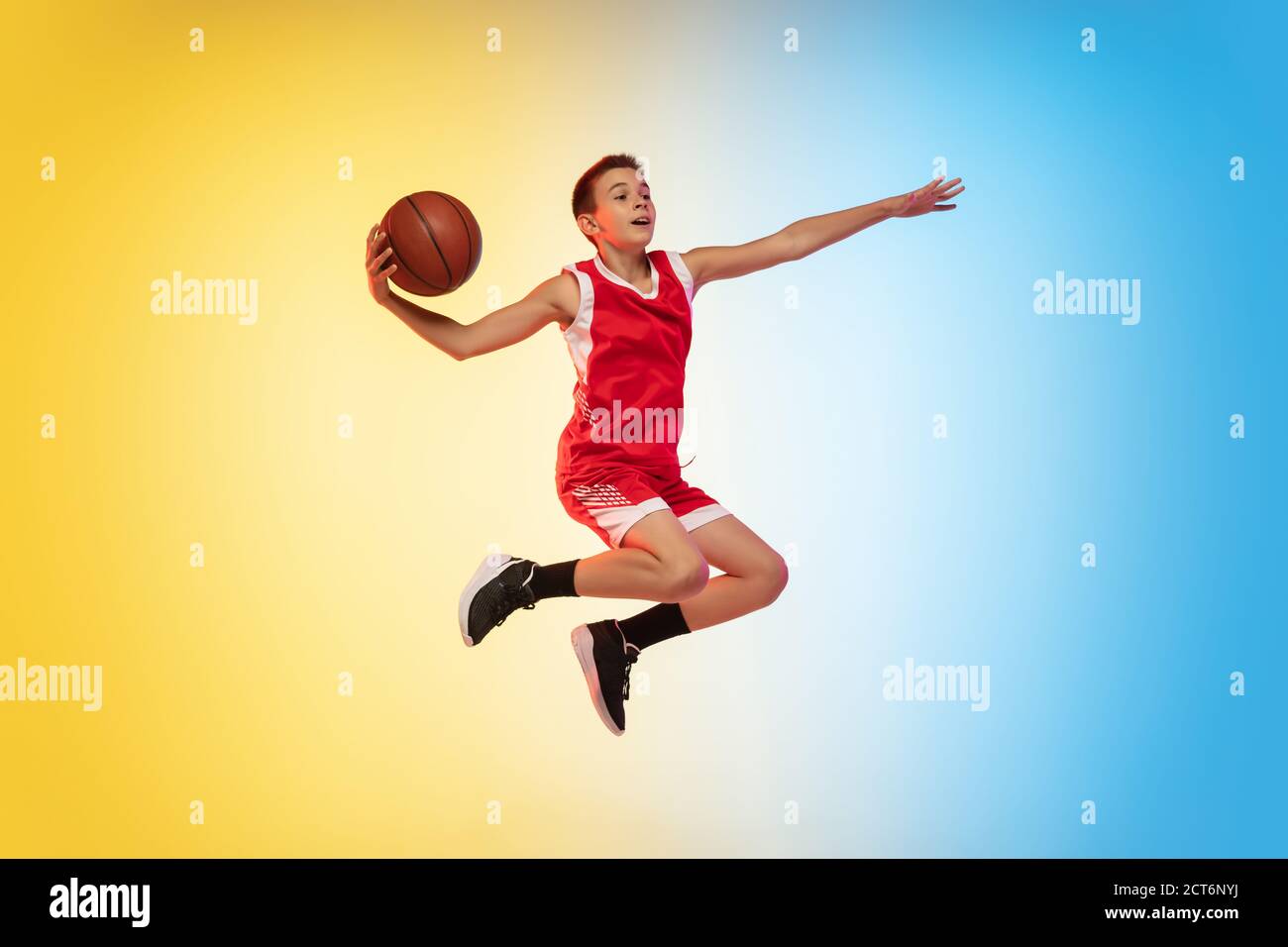 Jump high. Full length portrait of young basketball player in uniform ...