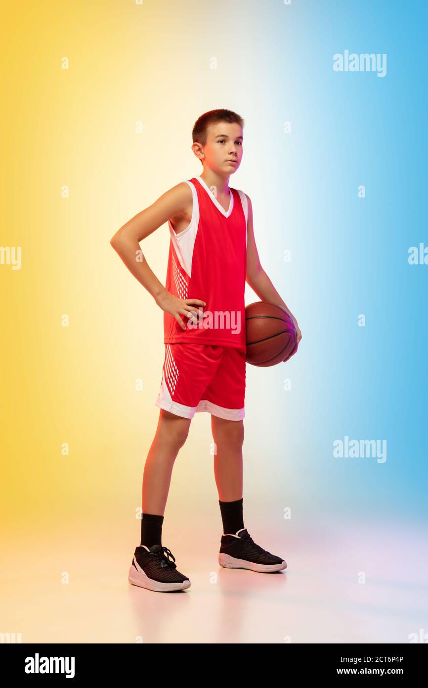 Full length portrait of young basketball player in uniform on gradient ...
