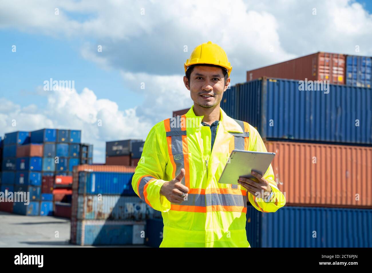 Young worker man with digital tablet at container terminal port ...
