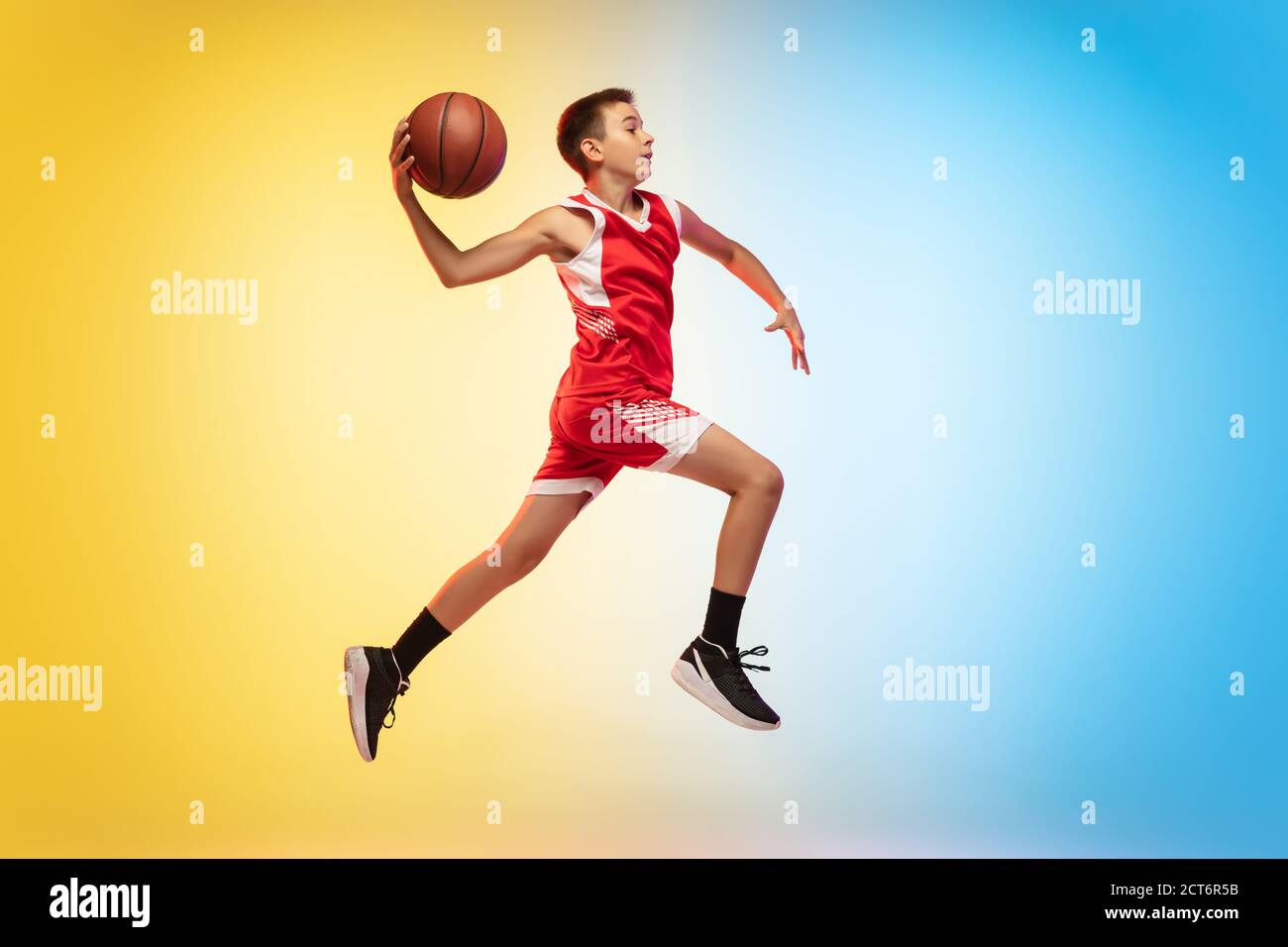 Jump high. Full length portrait of young basketball player in uniform ...