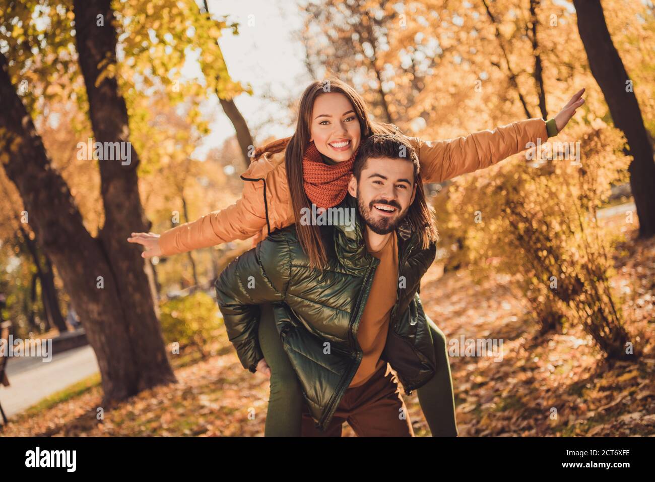 Photo of romantic couple guy hold piggyback girl with hands flying in ...