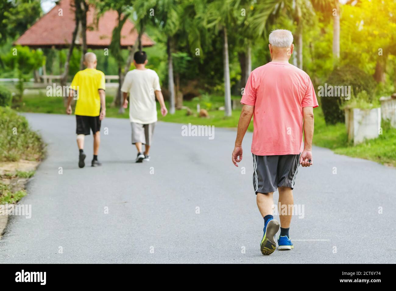 Back view portrait of a Asian elderly man in fitness wear walking and ...