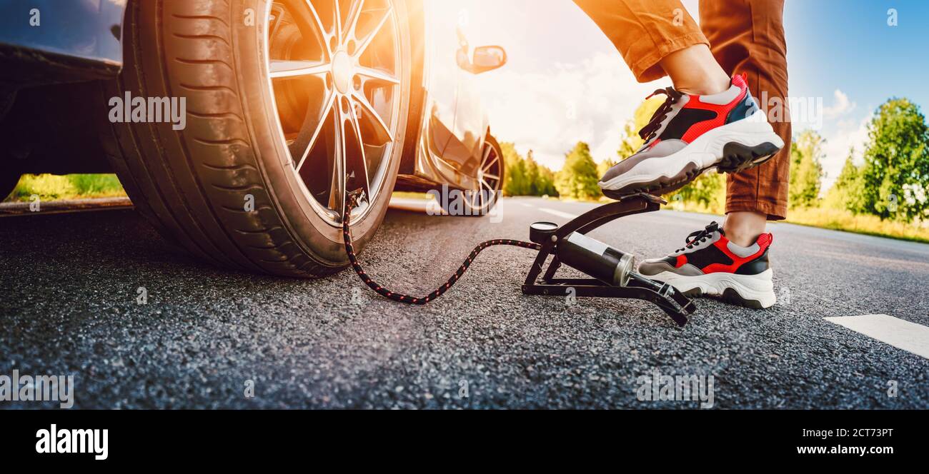 Driver using a foot pump to inflate a tire Stock Photo - Alamy