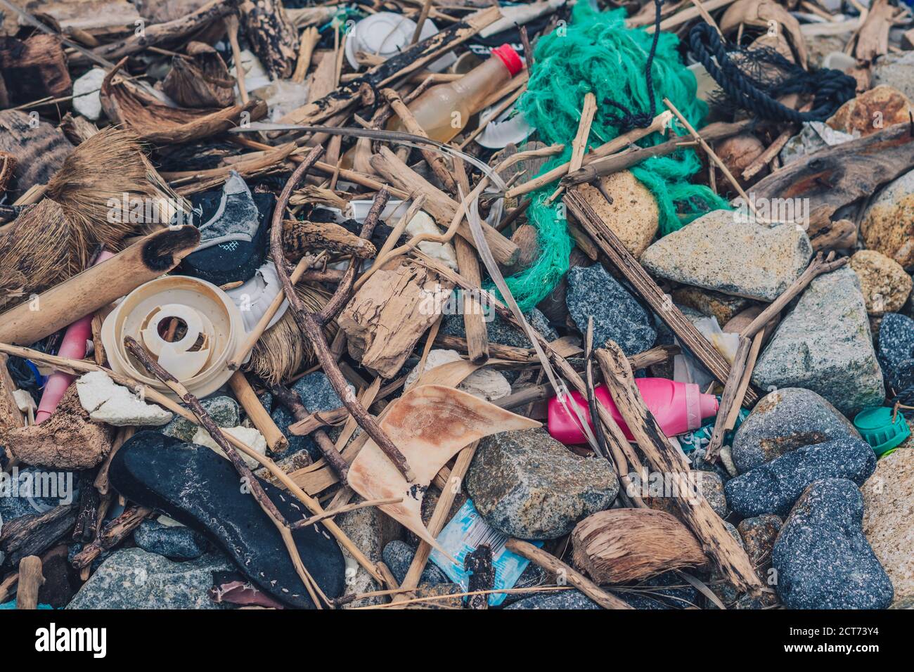 Spilled garbage on sea shore stones gray gravel. Empty used dirty waste ...