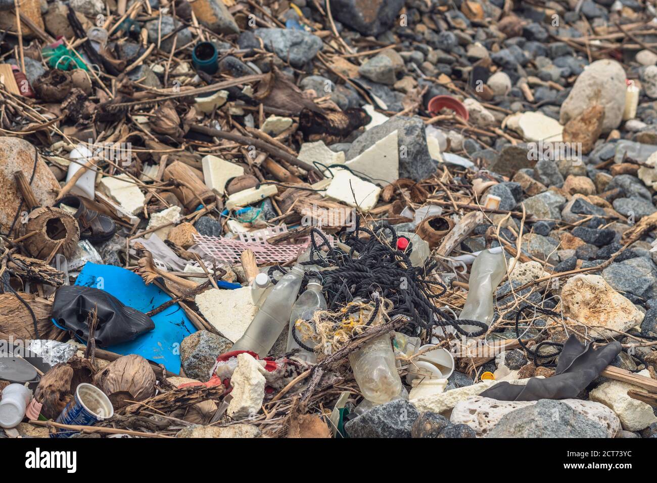 Spilled garbage on sea shore stones gray gravel. Empty used dirty waste ...