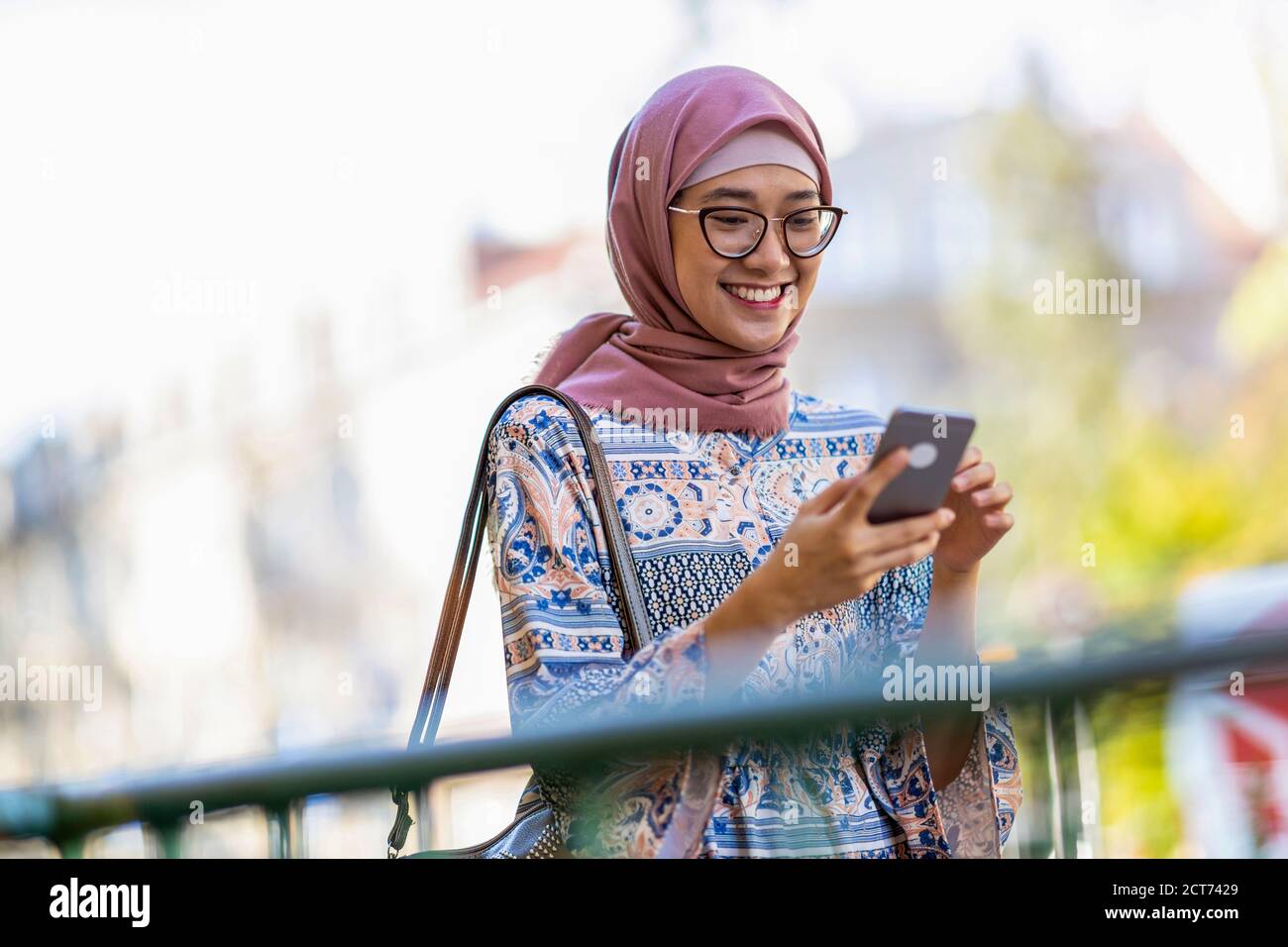 Muslim girl headscarf phone laughing hi-res stock photography and ...
