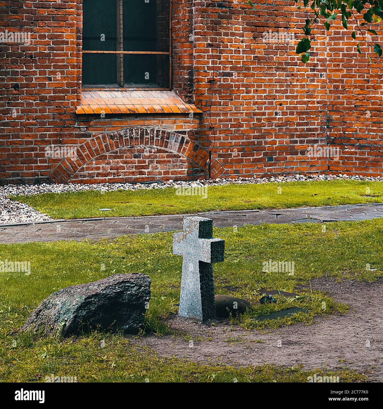 An ancient tombstone with a stone cross is unknown to anyone near the ...