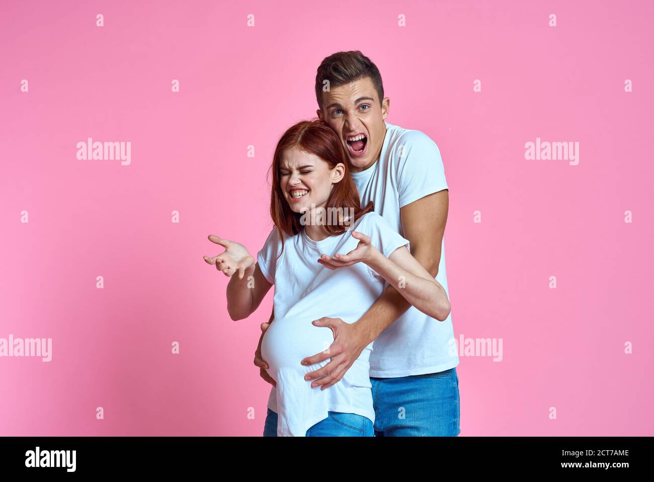 pregnant mom and happy father on pink background Young family waiting ...