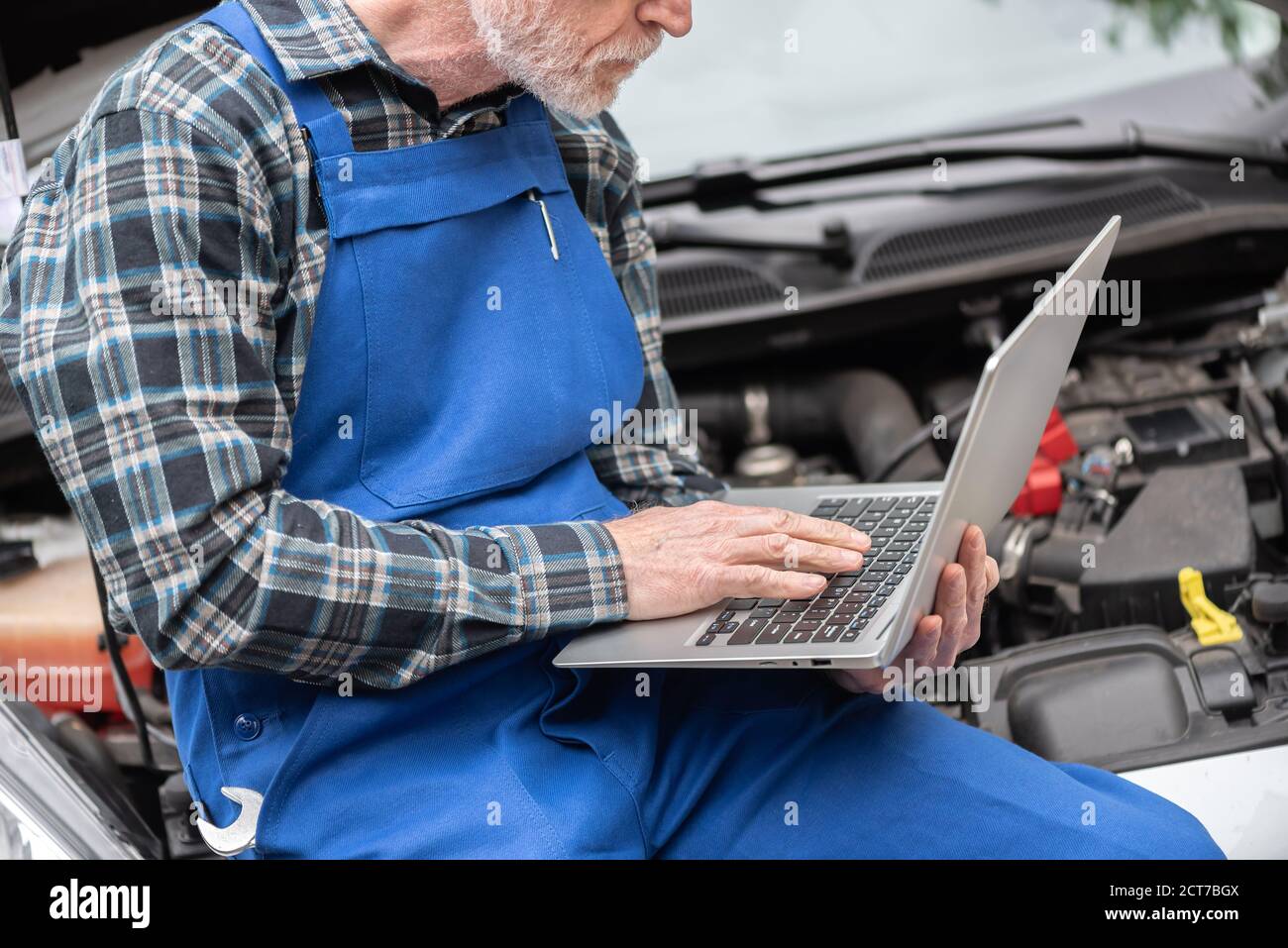 Car mechanic using laptop for checking car engine Stock Photo - Alamy