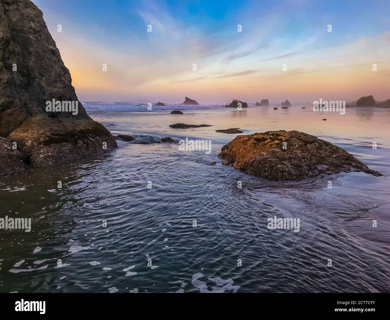 Beautiful tranquil ocean beach scene with rocks and sunset Stock Photo ...