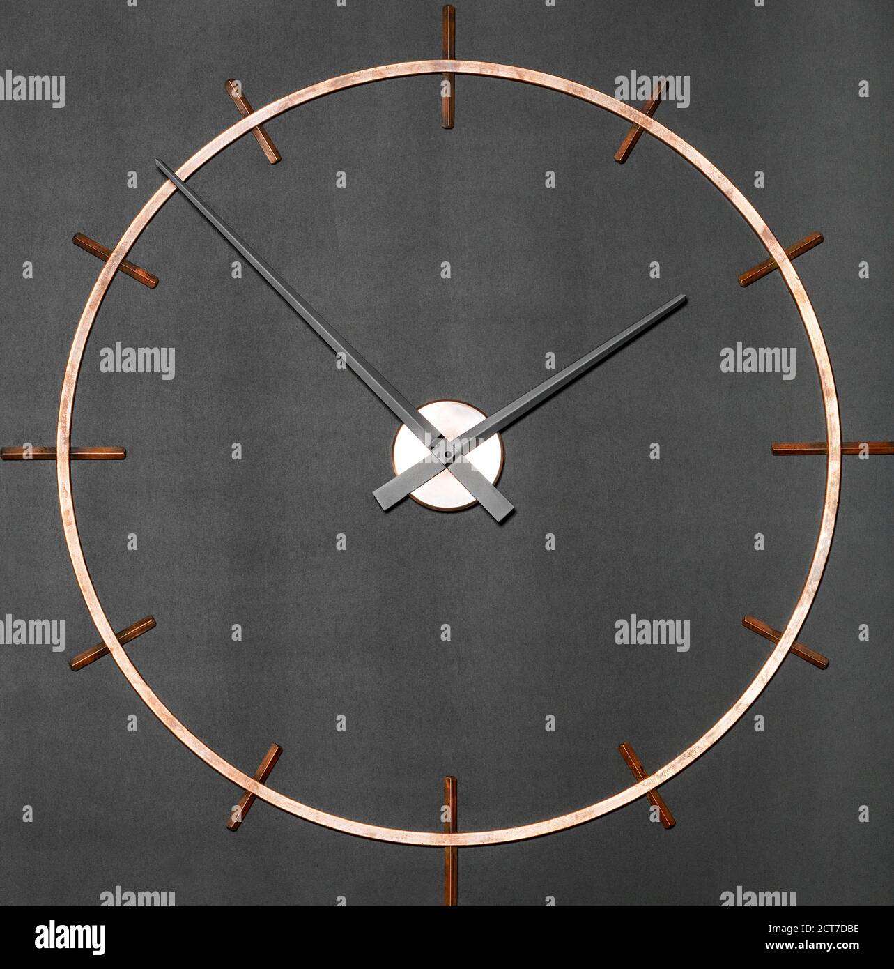 Round industrial wall clock in brass on a granite black background ...