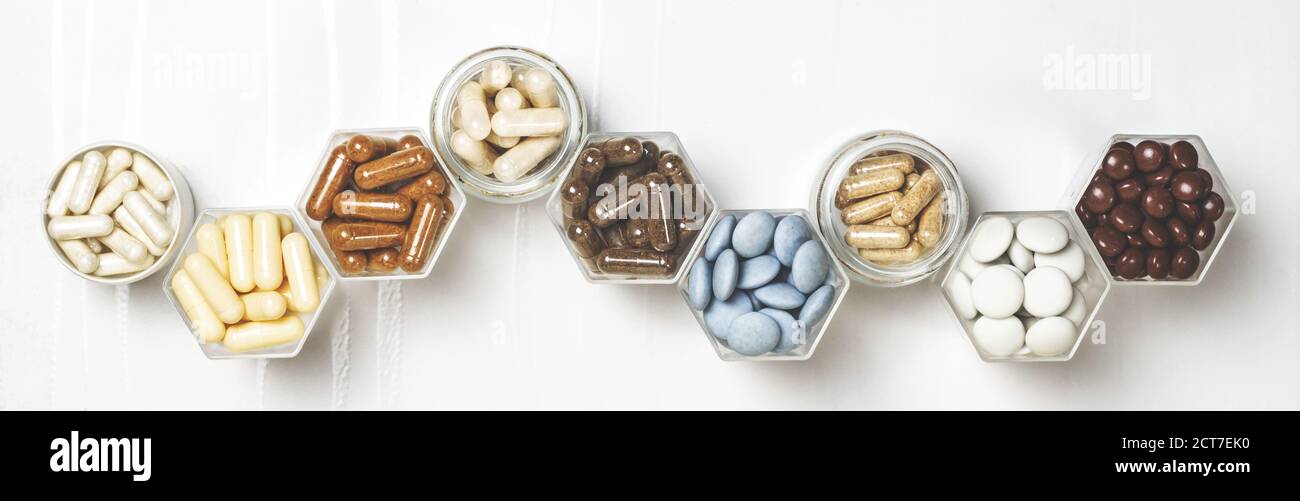 Various medical capsules and tablets in hexagonal jars in the form of ...
