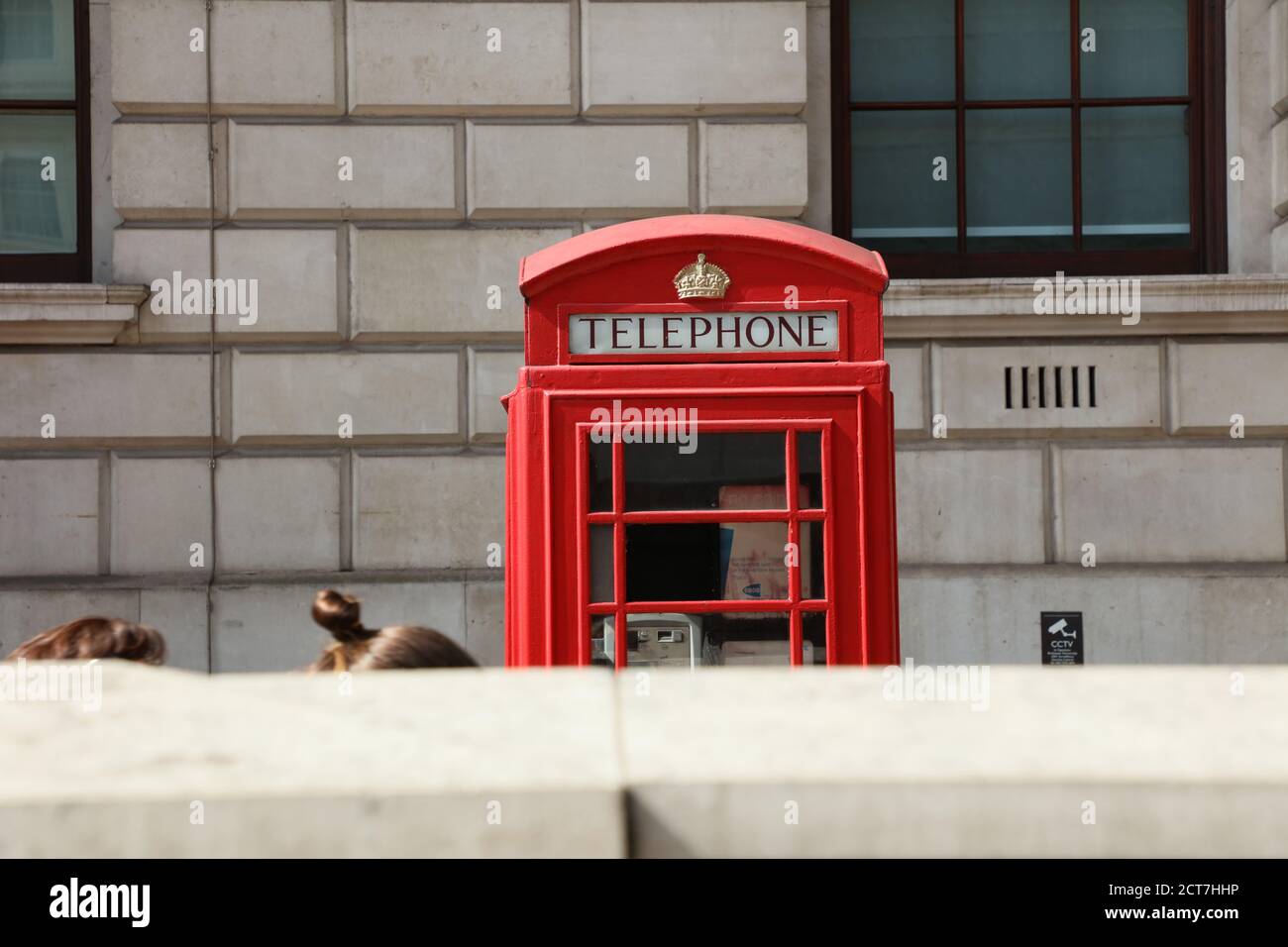 Part of an iconic and famous red telephone box seen against a building ...