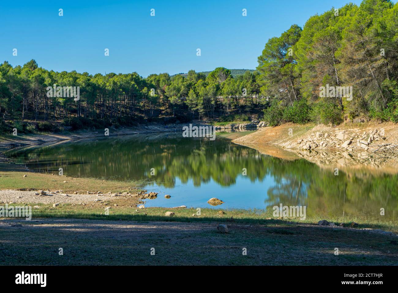 Reservoir landscape with nice reflections of the forest in the water on ...