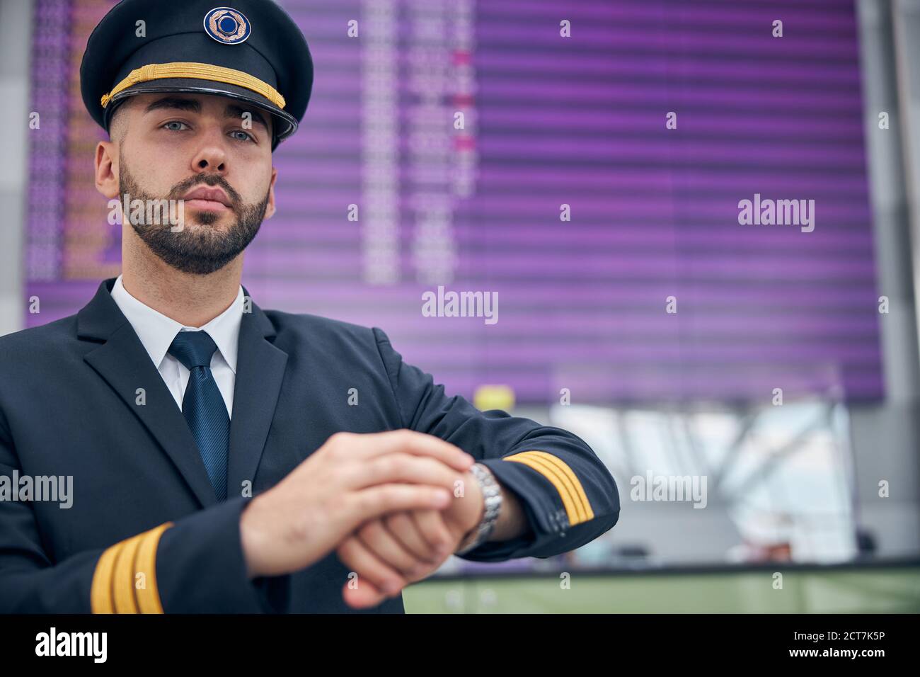 Handsome male pilot standing in airport terminal Stock Photo - Alamy