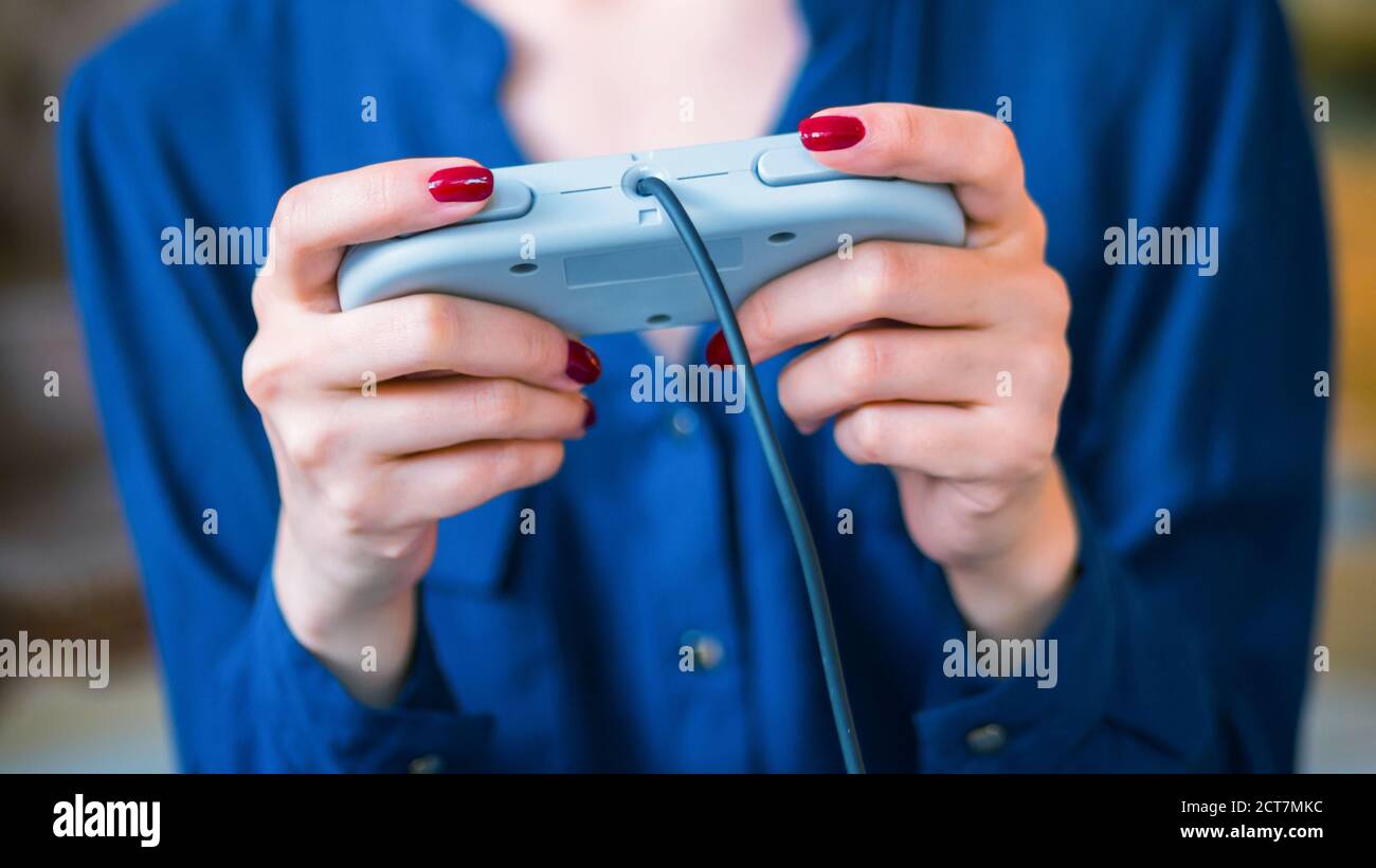 Woman using retro gaming console controller. Gaming, hobby, technology ...