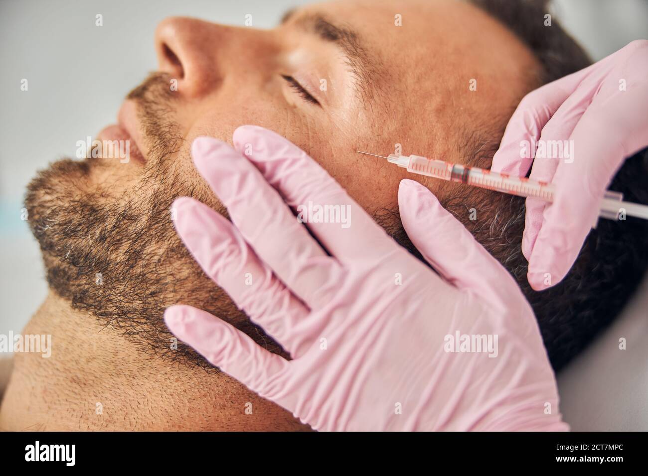 Serene young man receiving cosmetic facial injections Stock Photo - Alamy