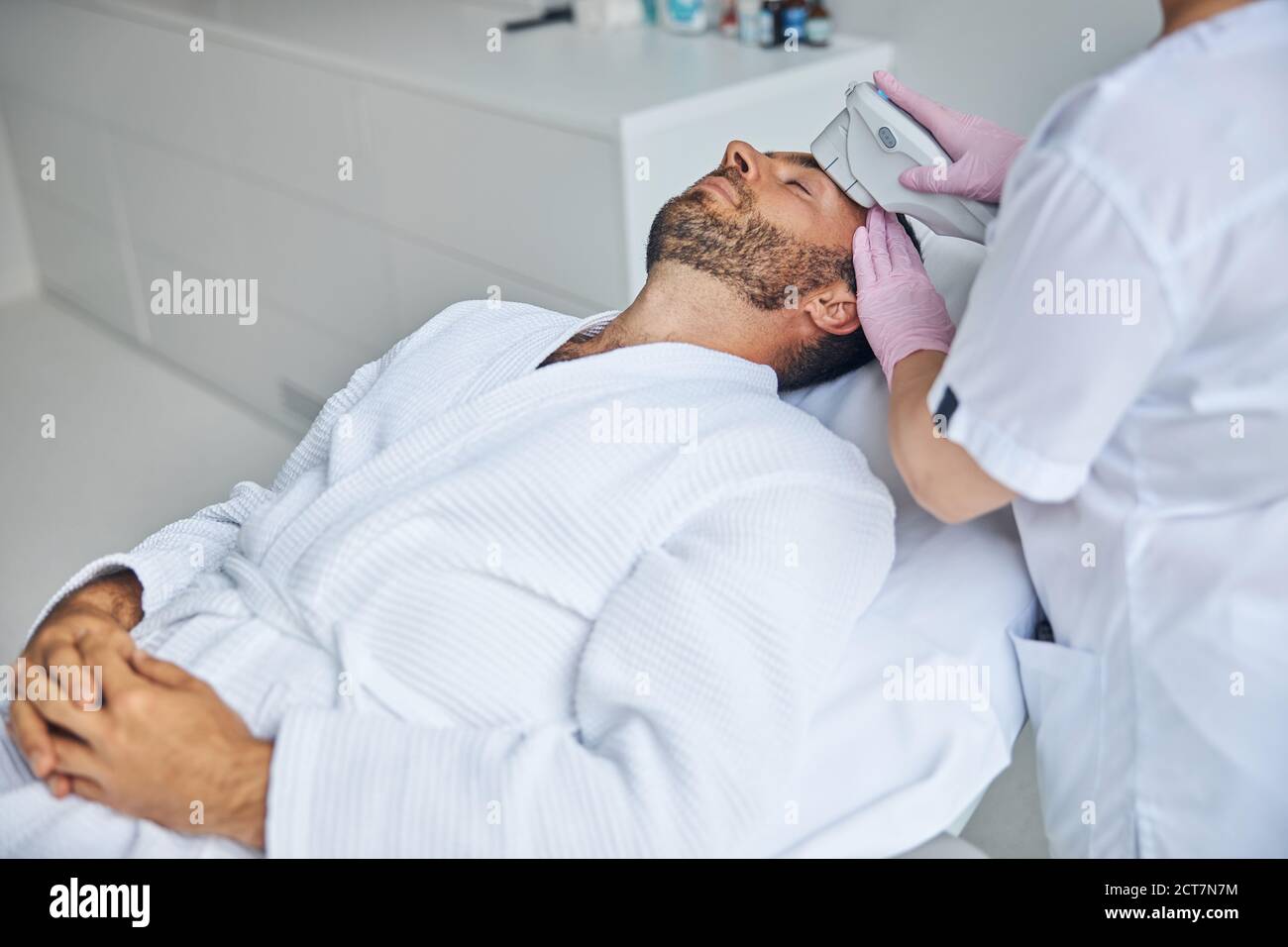 Female doctor esthetician treating male skin with laser device Stock ...