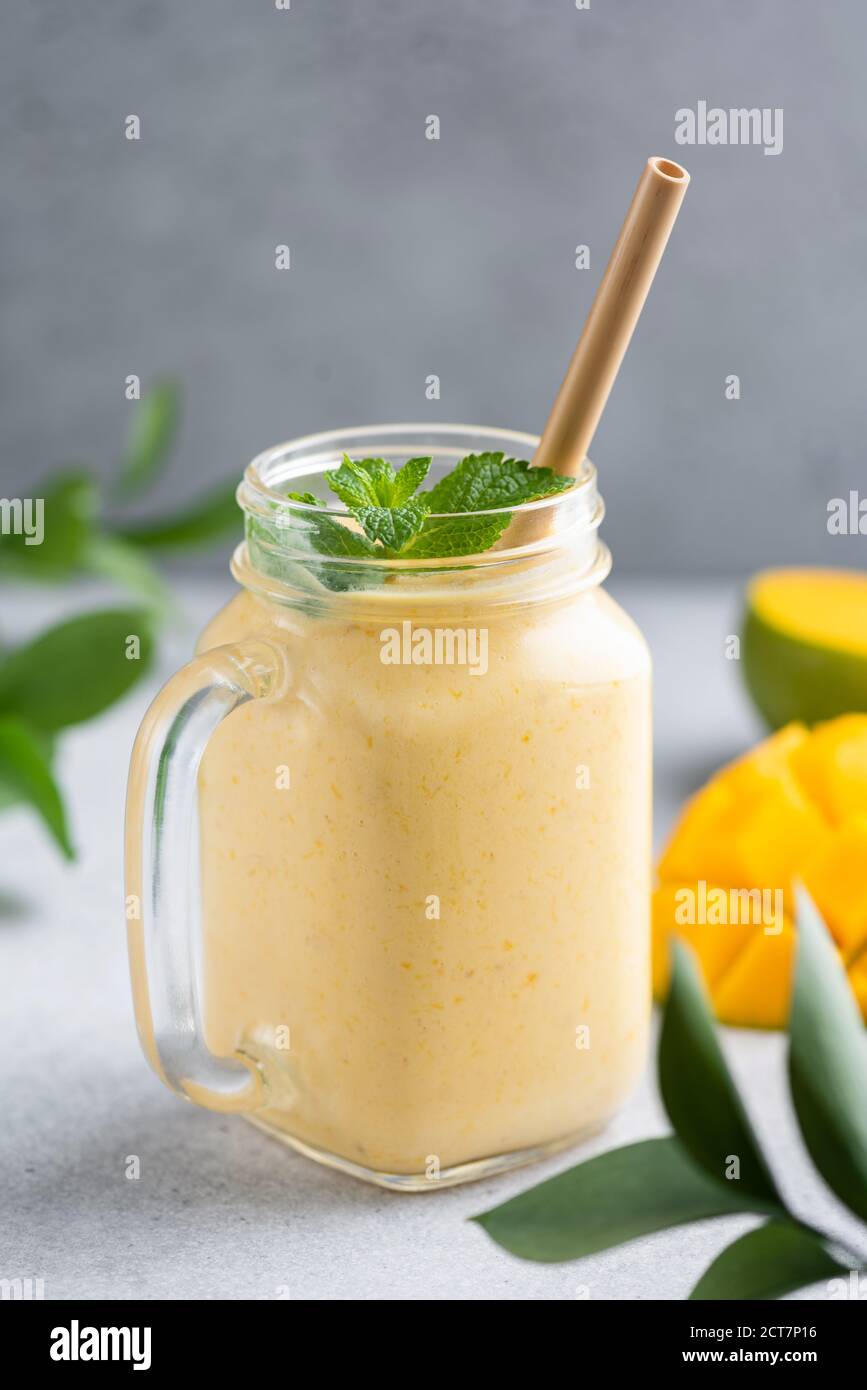 Fresh mango lassi in a glass jar. Healthy vegetarian mango smoothie ...