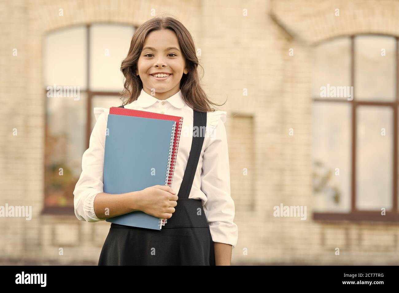 Learning language. Cute smiling child hold book. Little girl school student. Knowledge day ...