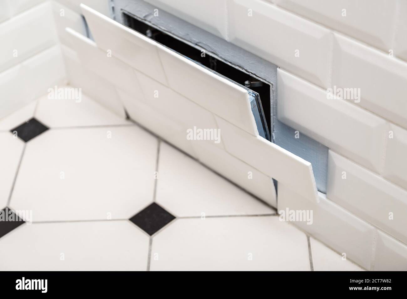 Open hidden revision sanitary hatch on the wall of tile under the ...