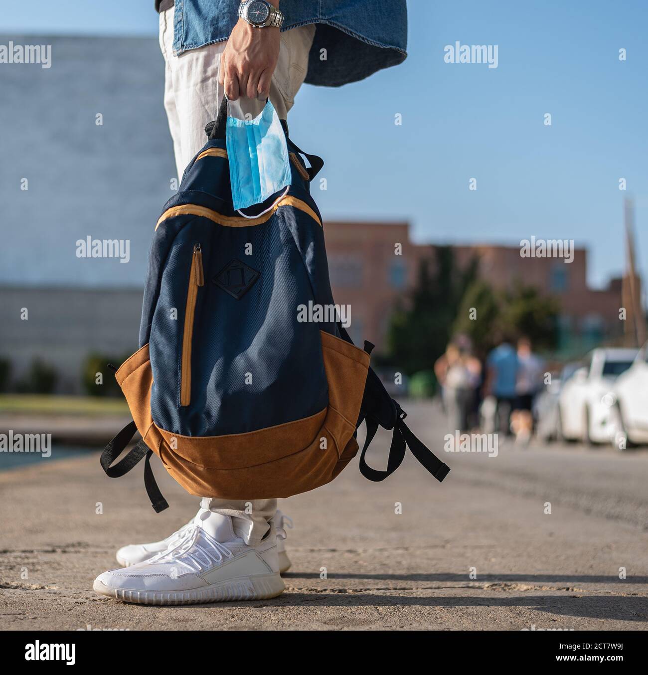 Student holding backpack and face mask outdoors Stock Photo - Alamy