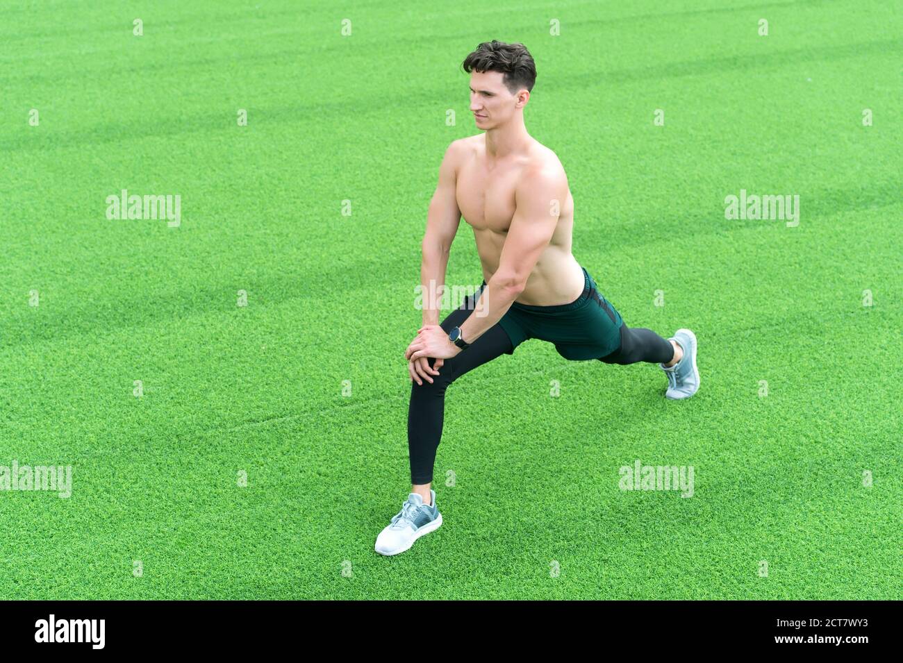 Muscular athlete warming up before workout outdoors, sport concept ...