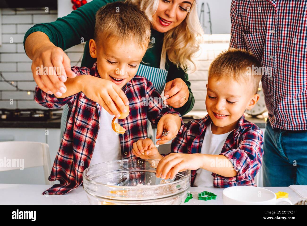 Happy family of mother, father and two children twins sons bake cookies ...