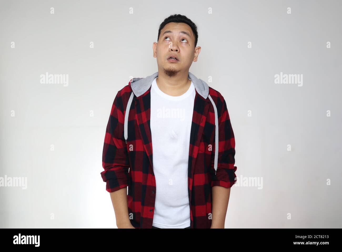 Funny young confused Asian man thinking expression, looking up ...