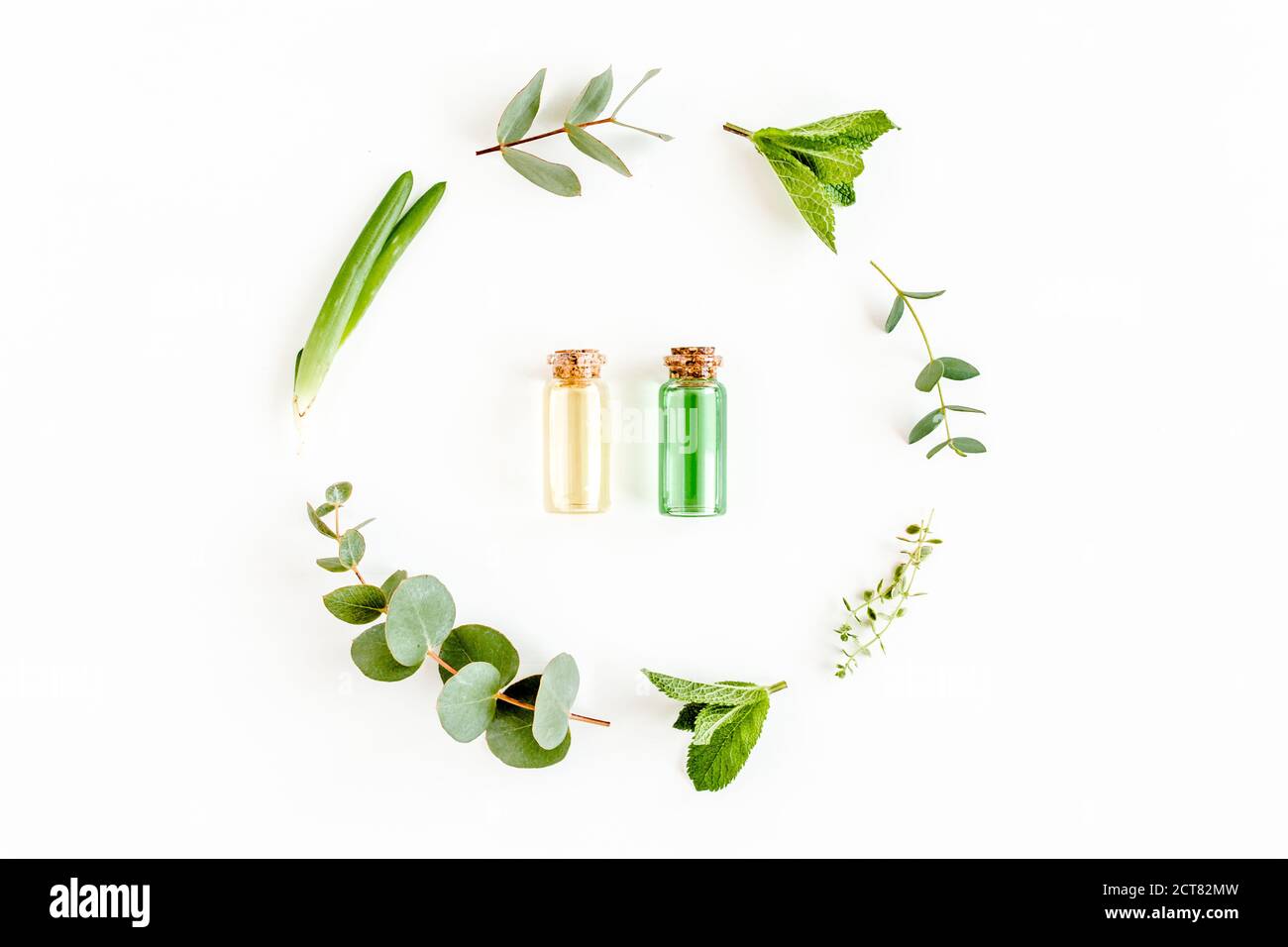 Essential oil and round wreath frame made of mix of herbs, green ...