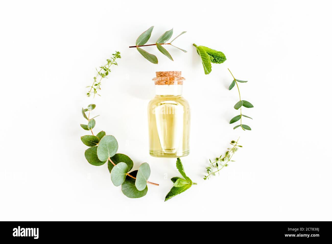 Essential oil and round wreath frame made of mix of herbs, green ...