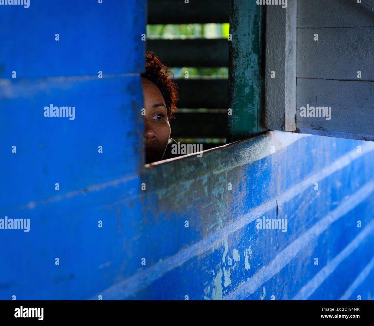 BARACOA, CUBA - CIRCA JANUARY 2020: Cuban woman looking from a window ...